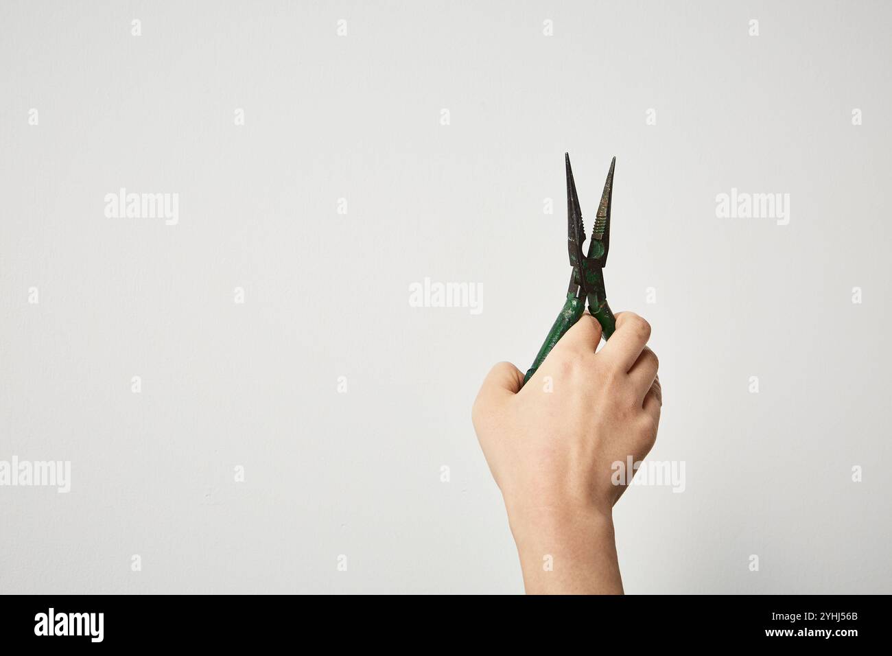 Woman's hand holding pliers Stock Photo - Alamy