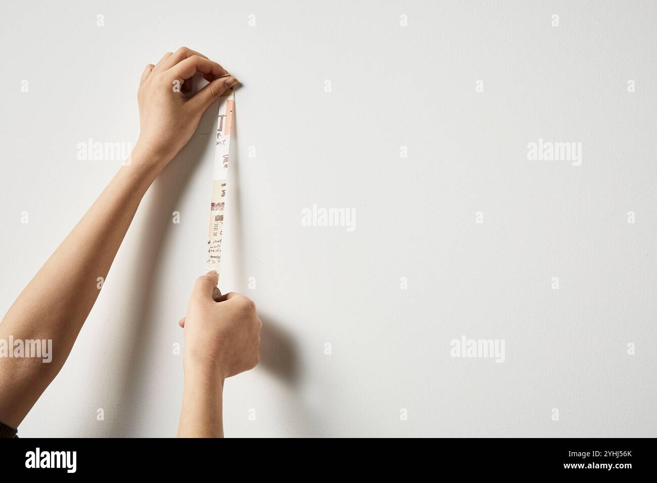 Woman's hand applying masking tape Stock Photo - Alamy
