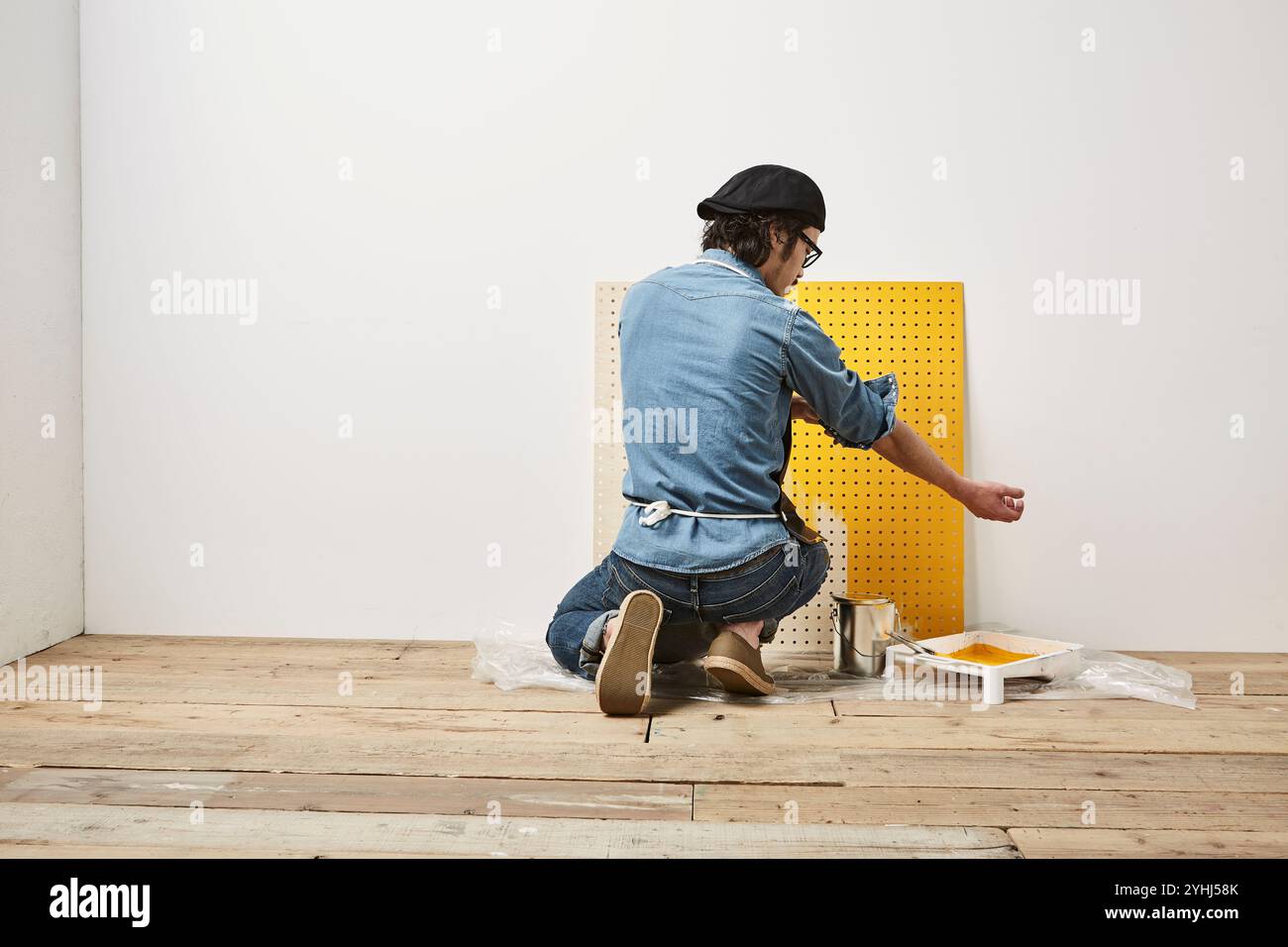 Man painting perforated panels Stock Photo - Alamy
