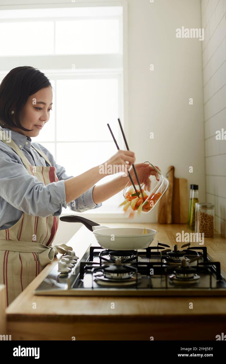 Woman cooking in kitchen Stock Photo - Alamy