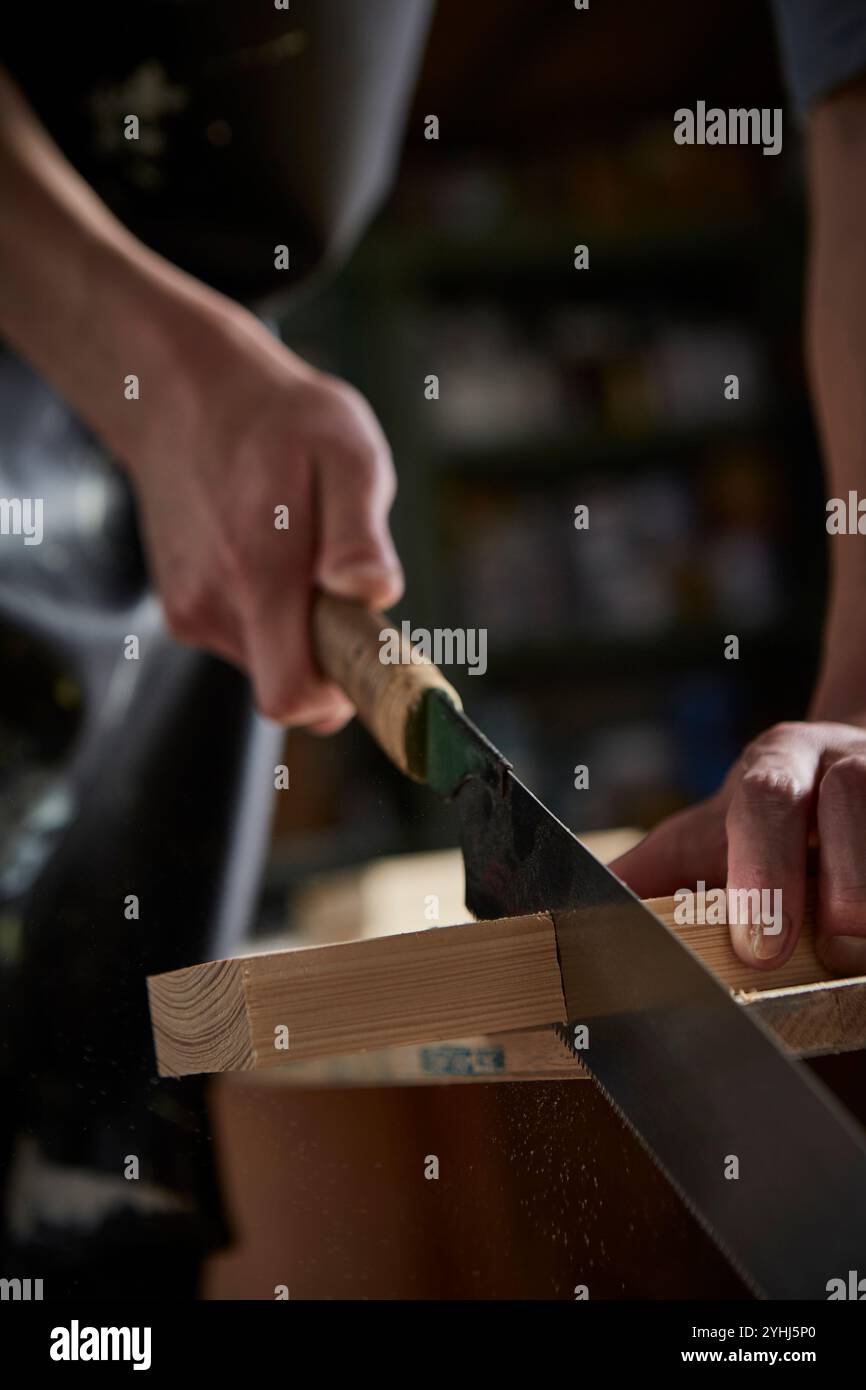 Man cutting wood with saw Stock Photo - Alamy