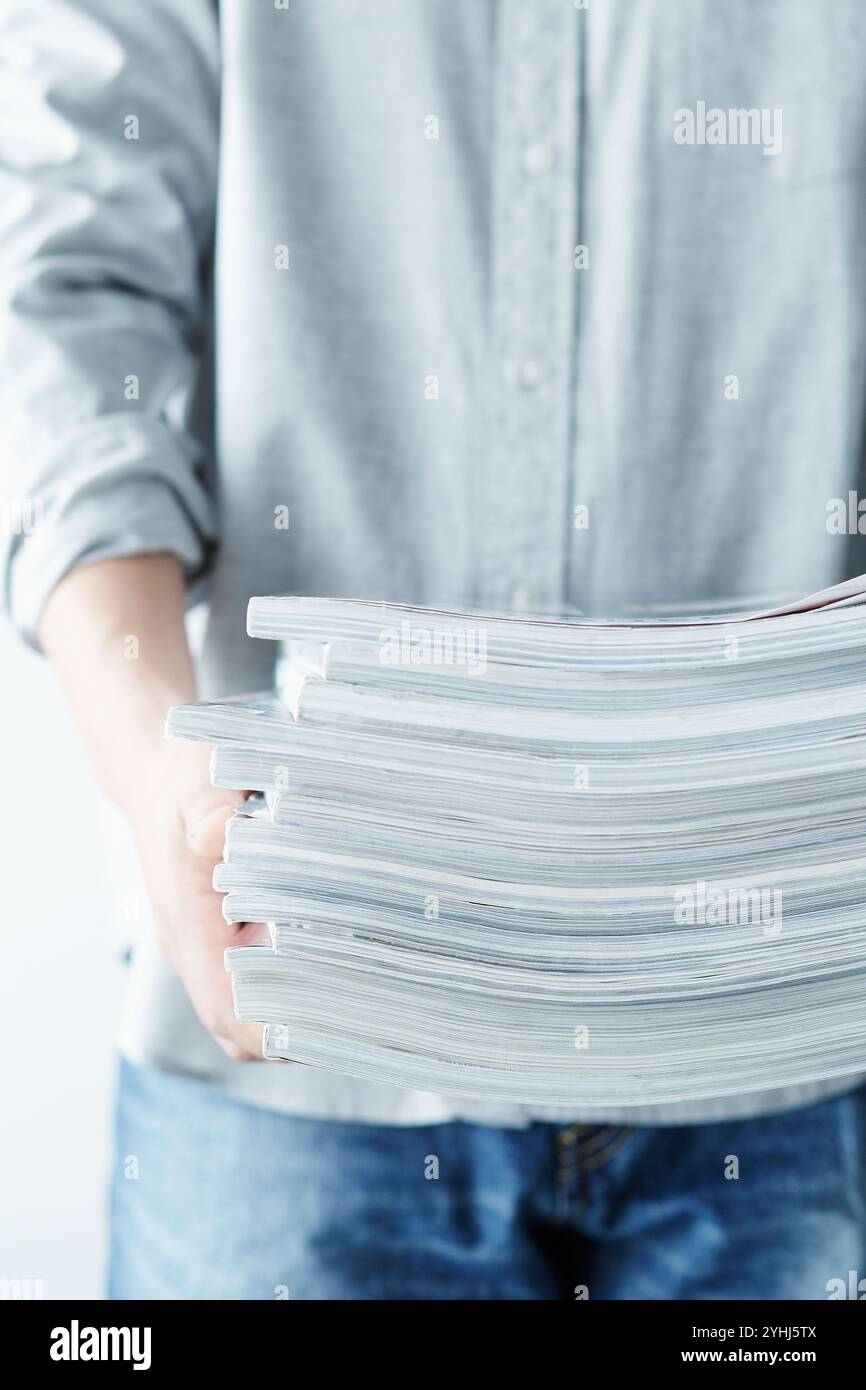 Man with pile of magazines hi-res stock photography and images - Alamy