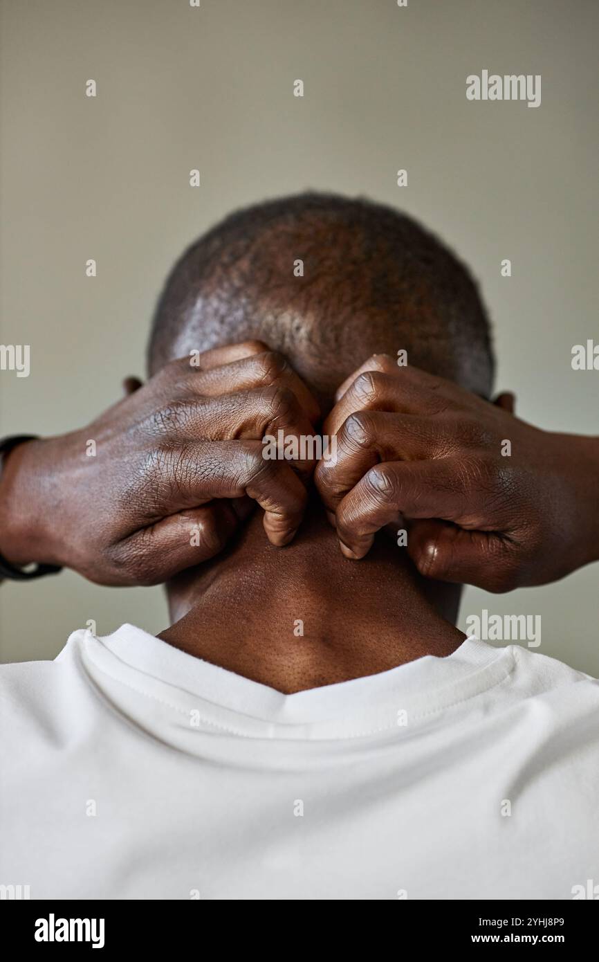 Vertical close up of African American man scratching head and neck ...