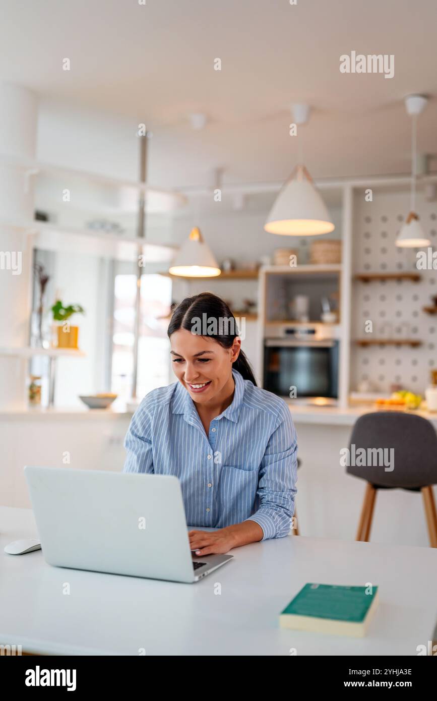 Young beautiful woman using computer to check social media, working or ...