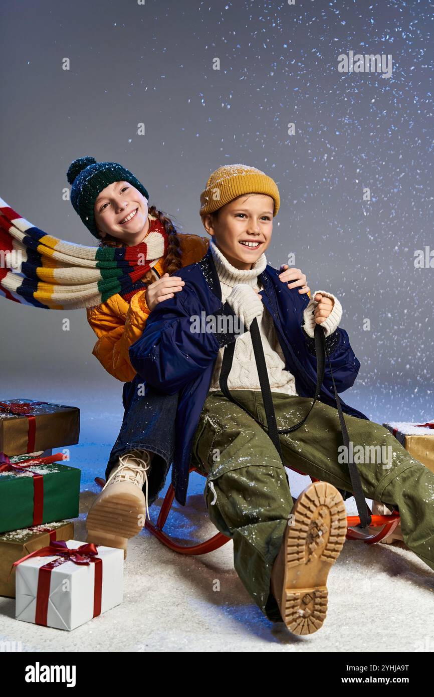 Two children gleefully ride a sled, surrounded by snowfall and holiday ...