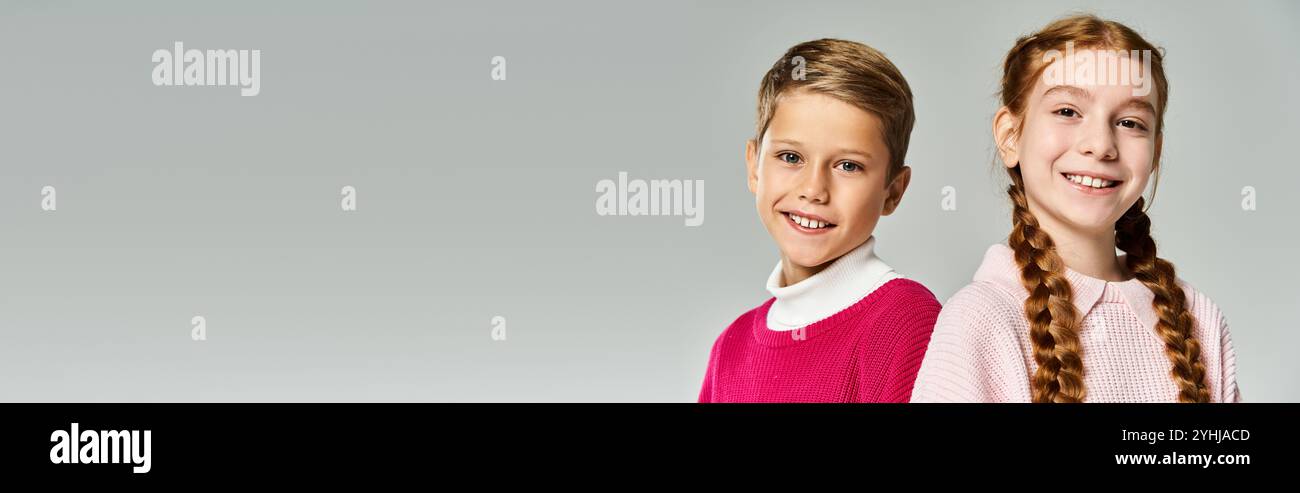 Two joyful kids wearing warm clothes express happiness during a chilly ...