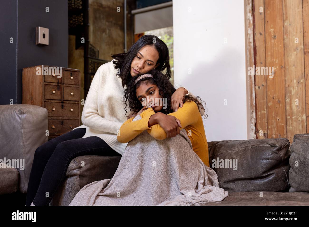 Comforting embrace on cozy sofa, two multiracial female friends sharing ...