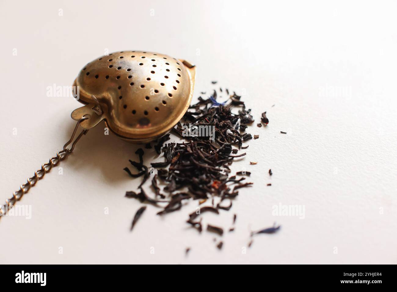 tea leaves inside of stainless steel tea bag and some of it scatter ...
