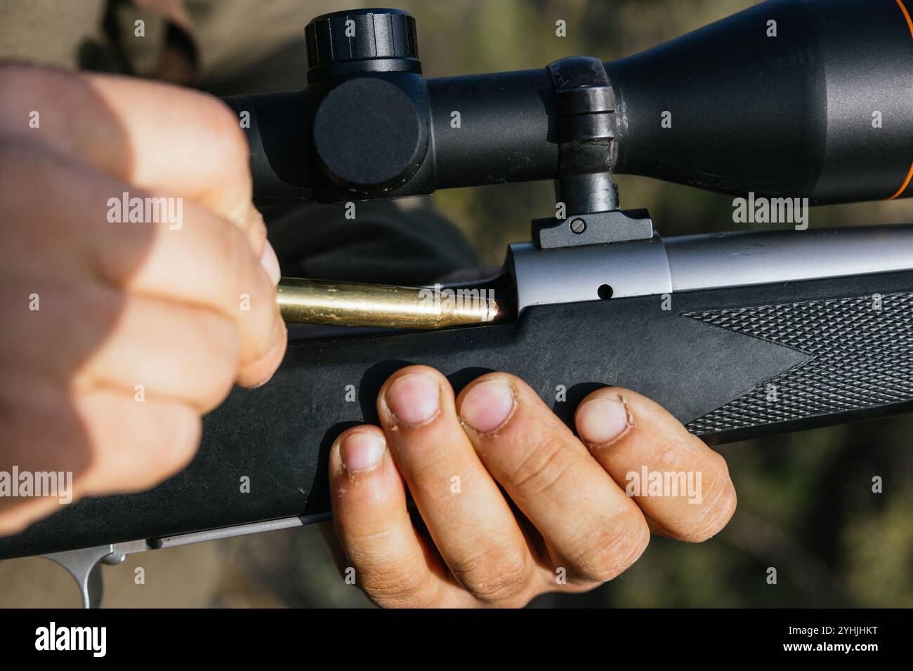 Hunter loading rifle with scope in forest Stock Photo - Alamy