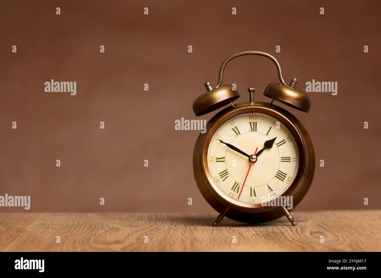 Old-fashioned alarm clock brown background Stock Photo - Alamy