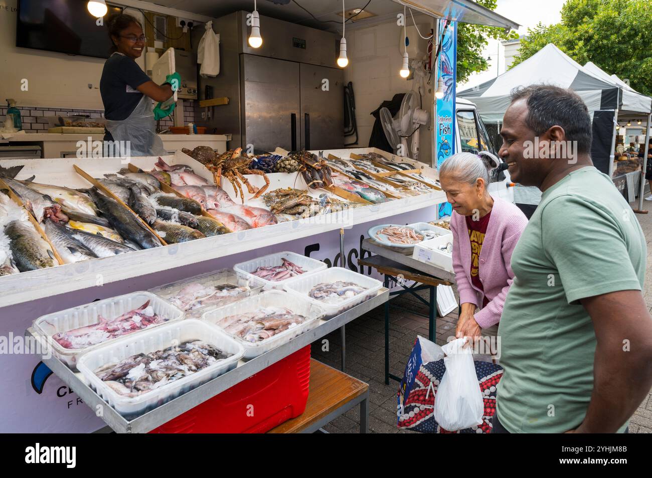 Mature lady shopping at fresh fish stall at street market St Albans ...