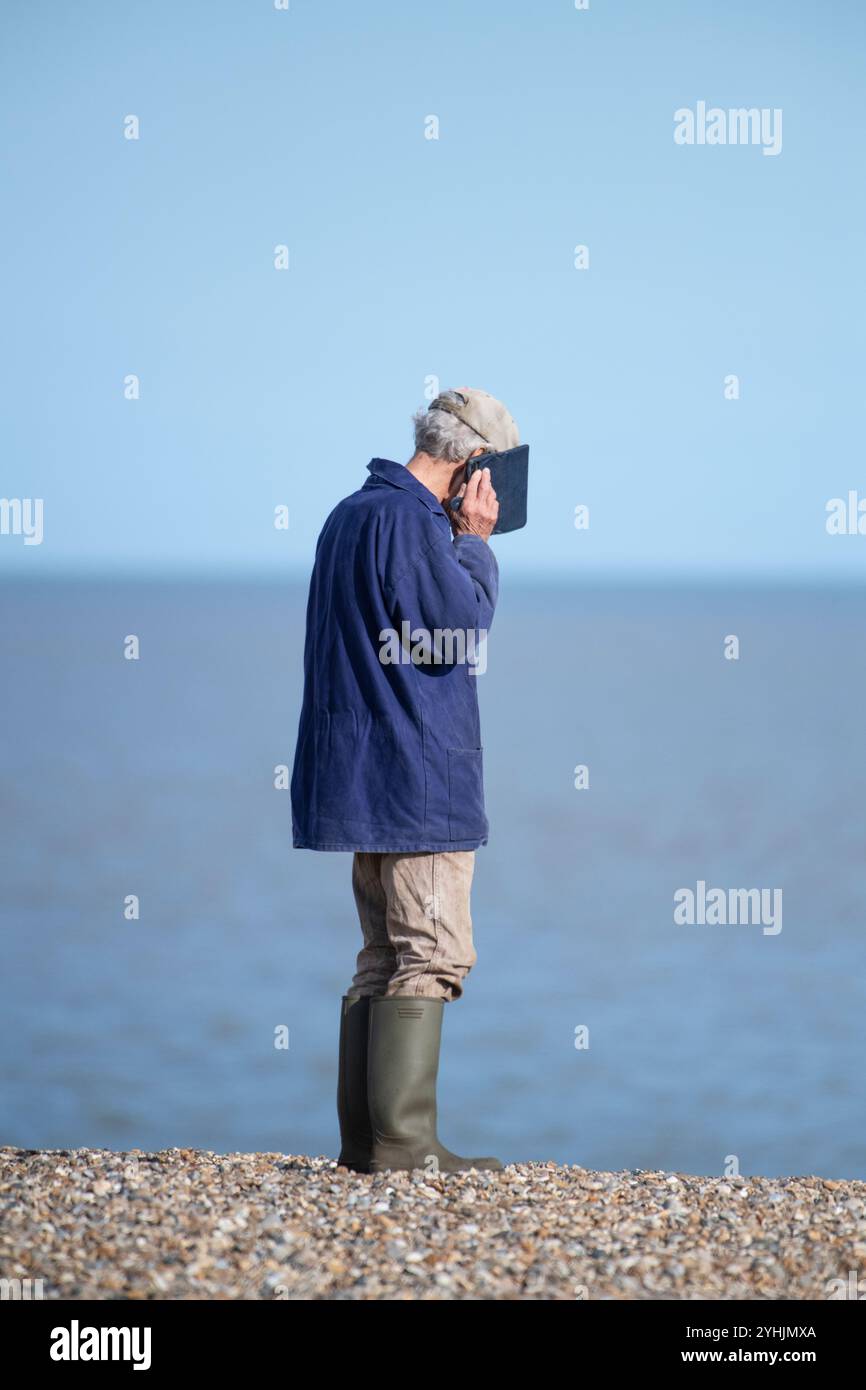 beach fisherman using mobile phone , dunwich, suffolk, england Stock ...
