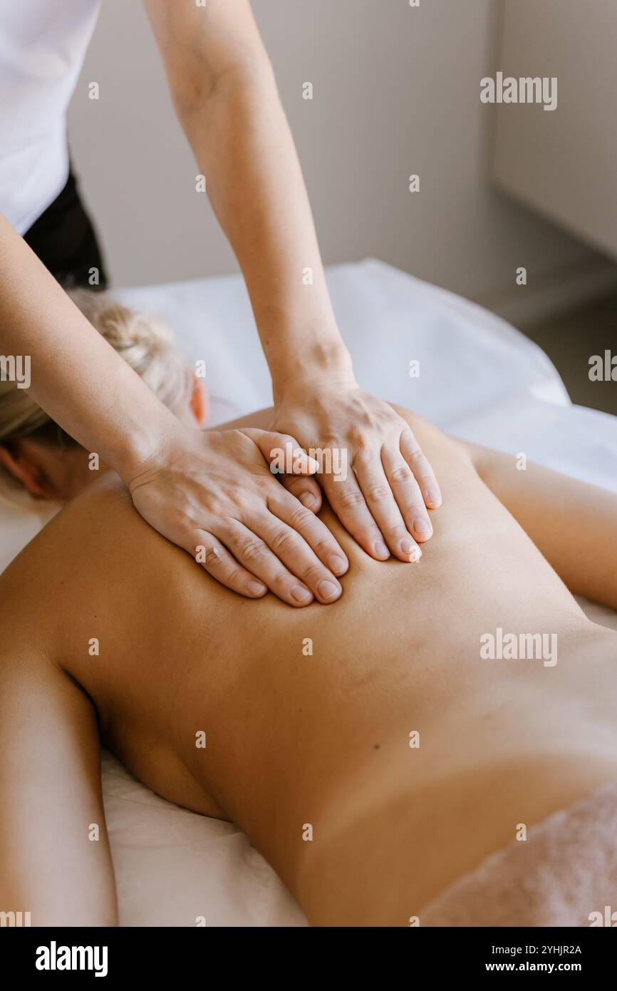 Therapist performing a soothing back massage for deep relaxation and ...