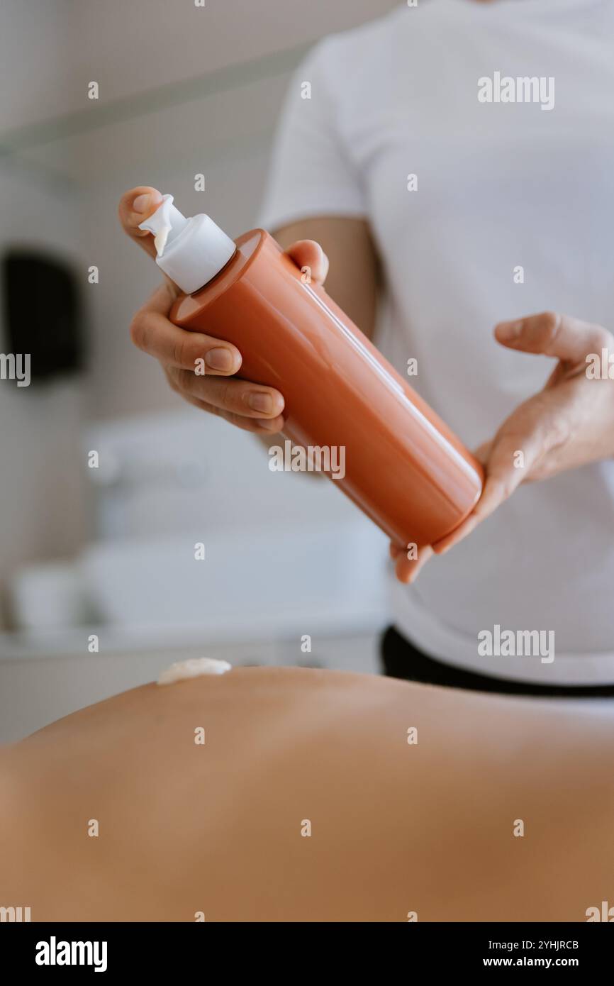 Applying soothing body lotion for a relaxing massage experience in a ...