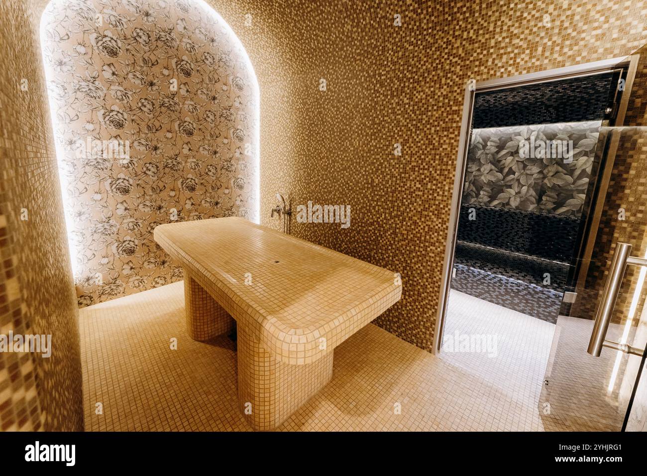 Luxurious spa steam room with tiled massage table and ambient lighting ...