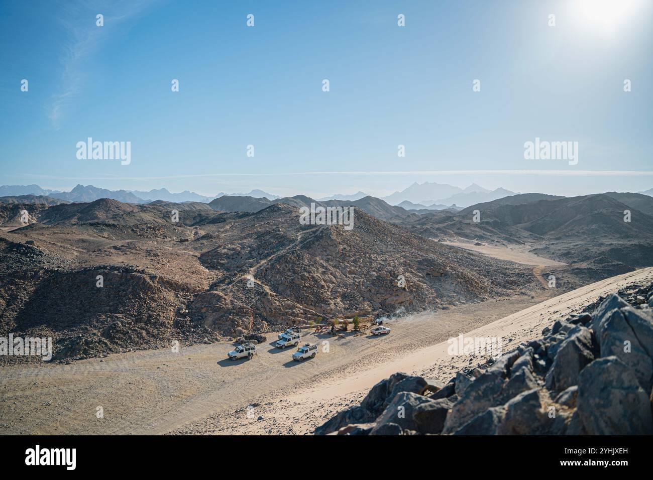 Cars and jeeps parked along a valley road in the desert in Egypt with ...