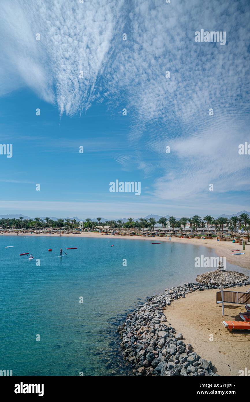 Stonewall breakwater at sandy beach in Egypt with palm trees and blue ...
