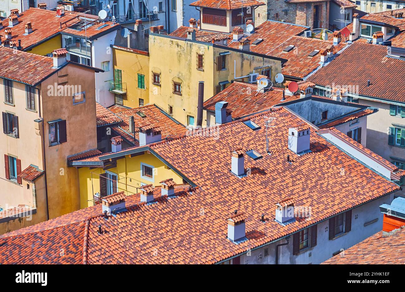 The old, densely packed housing of Bergamo Alta with red tiled roofs and shabby walls, Italy ...