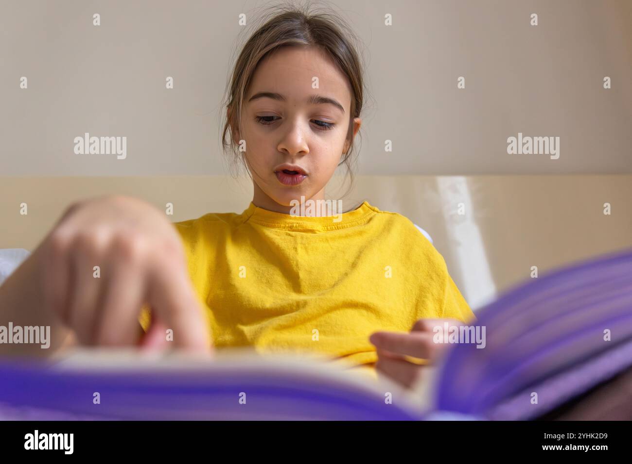 An interested and focused girl is reading a book. Emotion concept Stock ...