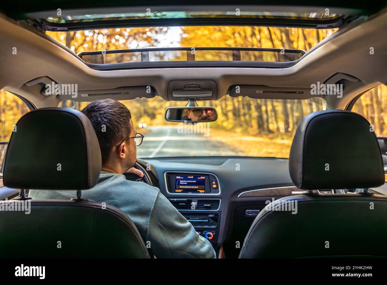 Driving the modern car on asphalt road. A young man drives a car Stock ...