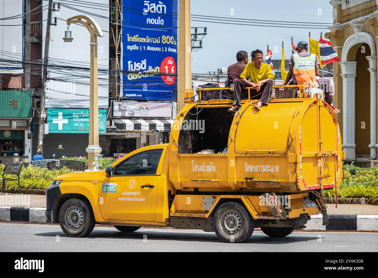 Yellow garbage truck. Recyclable garbage truck and men in uniform ...