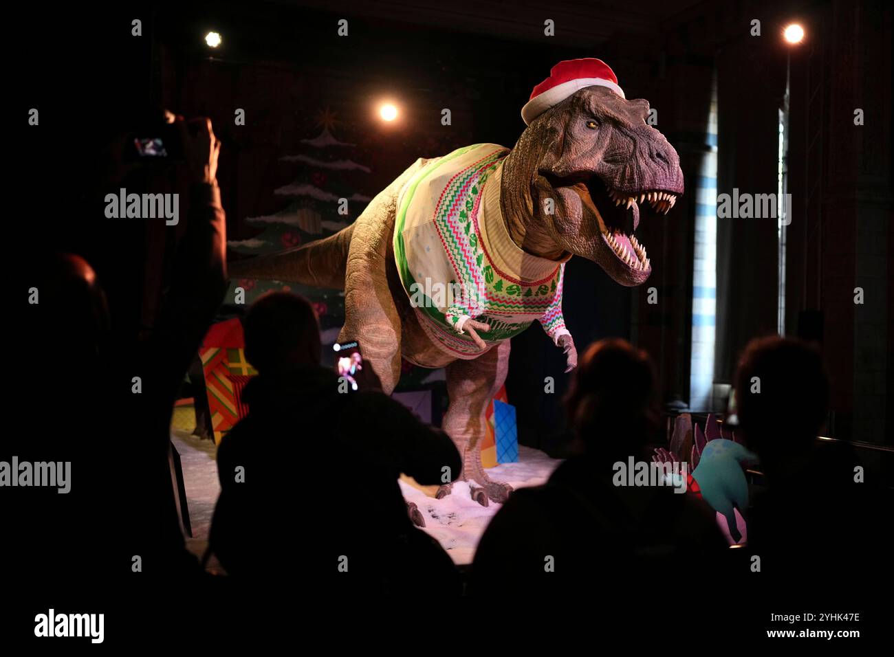 Visitors take photographs of an animatronic dinosaur Tyrannosaurus rex ...