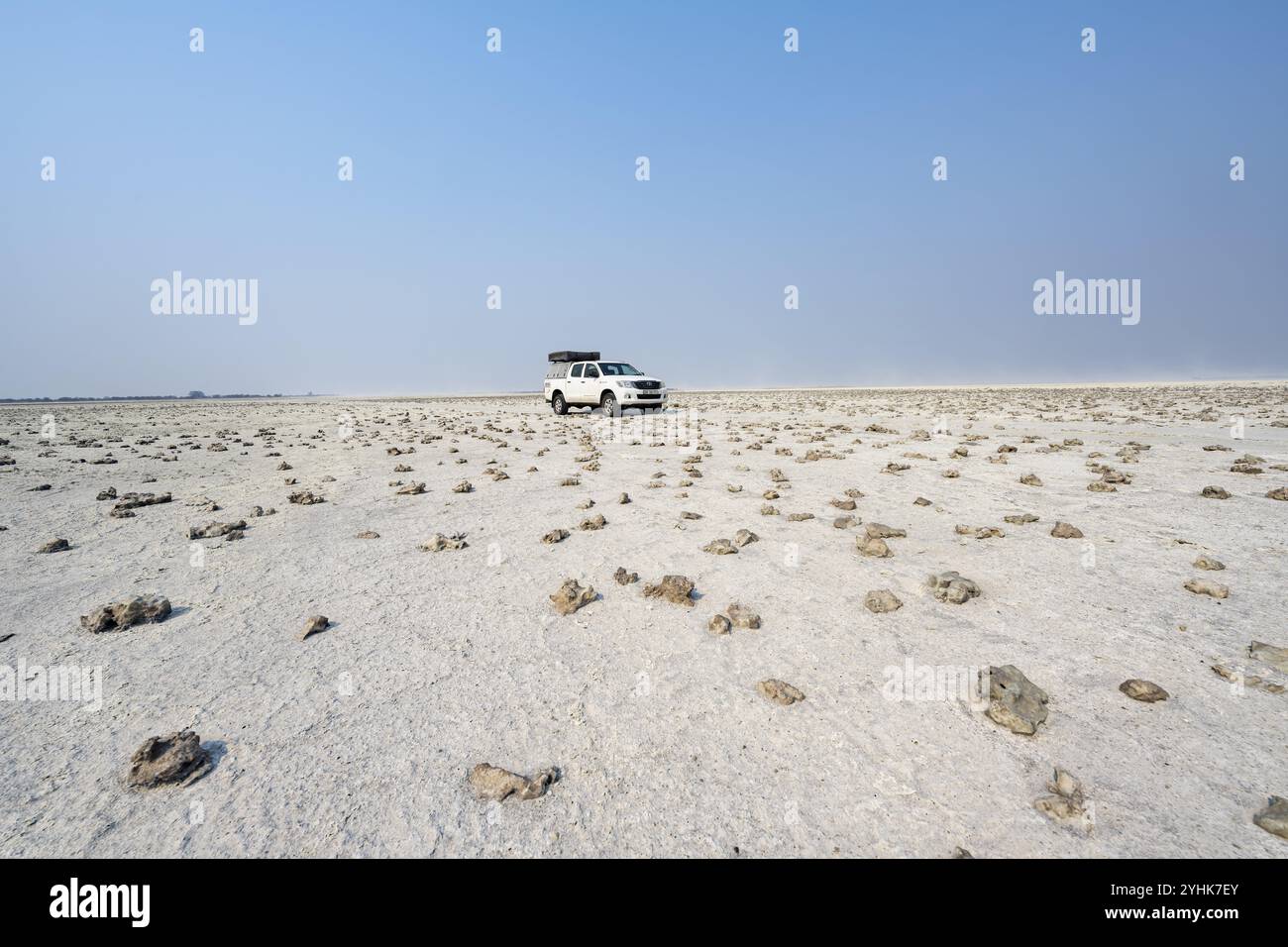 Four-wheel drive Toyota Hilux with roof tent, driving over salt pan ...