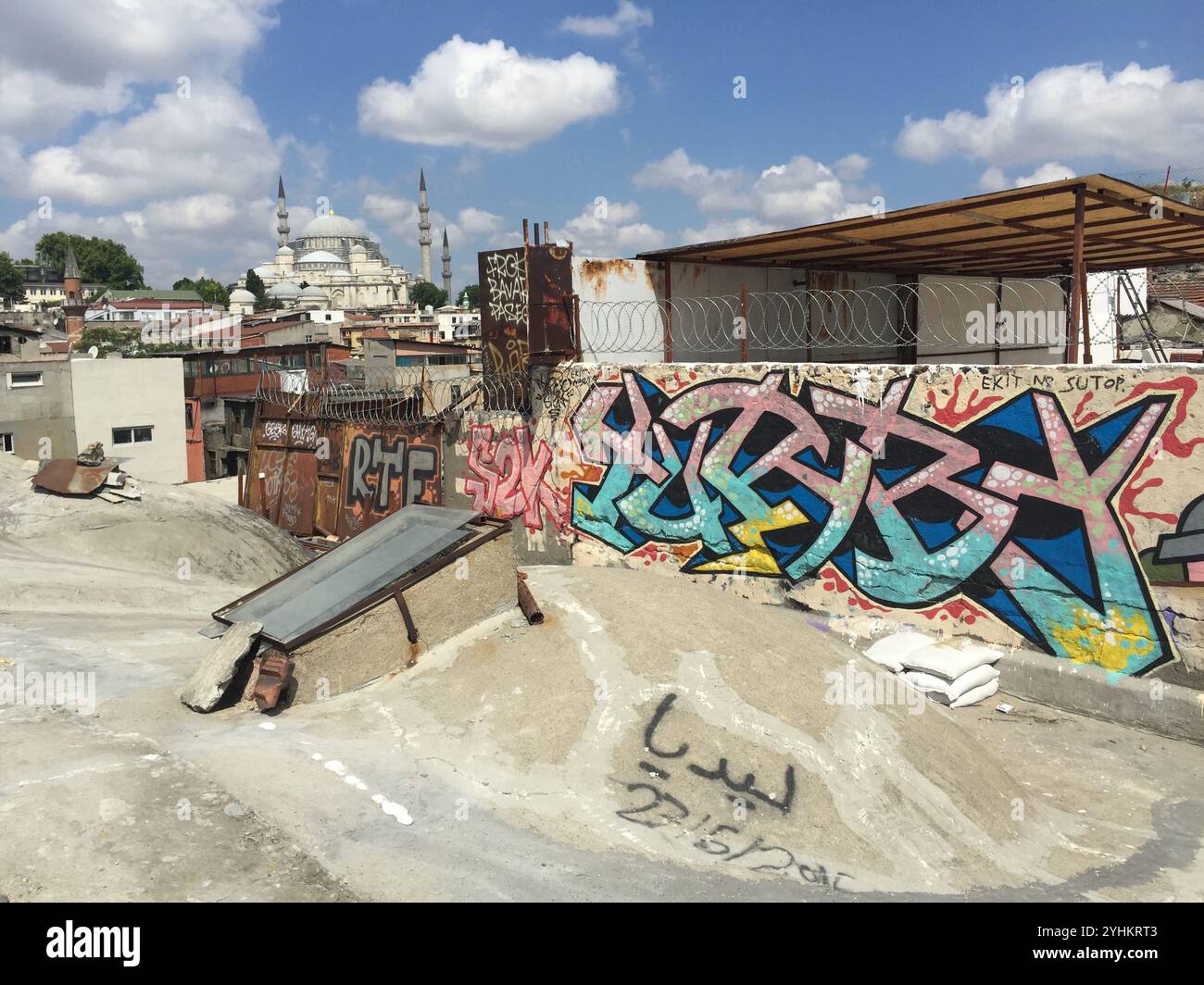 Urban rooftop view in Istanbul featuring colorful graffiti, barbed wire ...