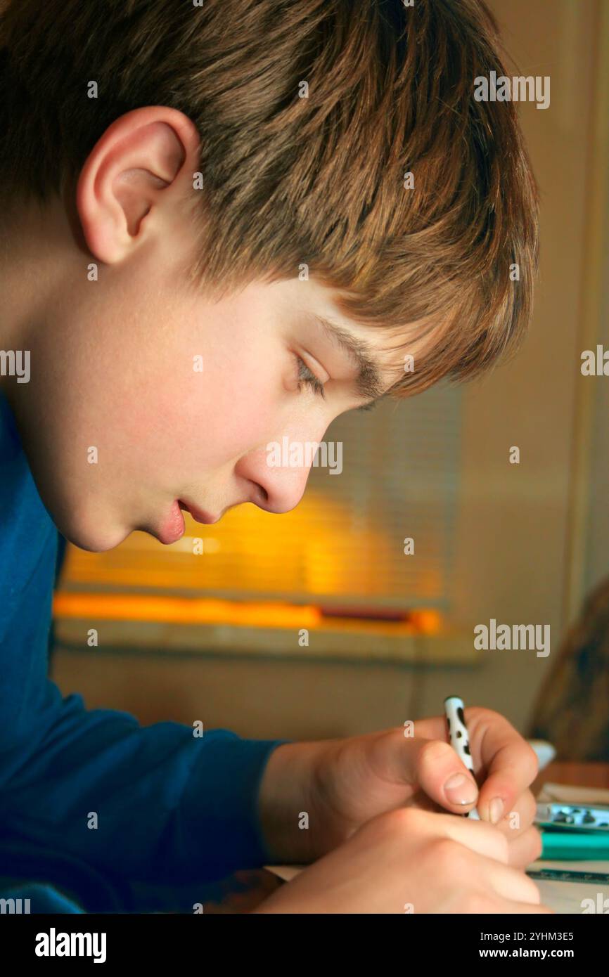 The boy doing lessons and with concentration drawing Stock Photo - Alamy
