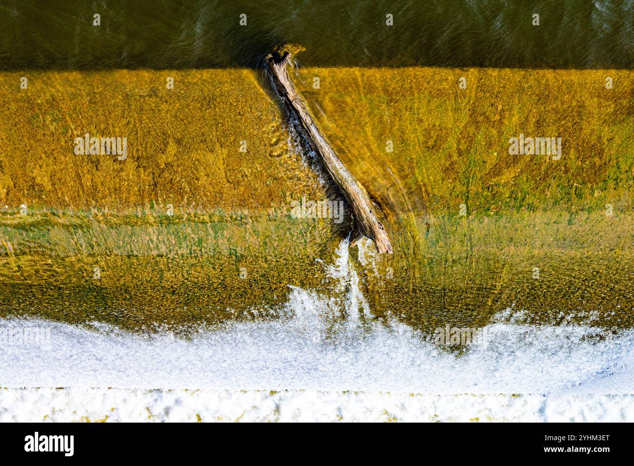 Fallen Log Resting on River Dam with Flowing Water Stock Photo - Alamy