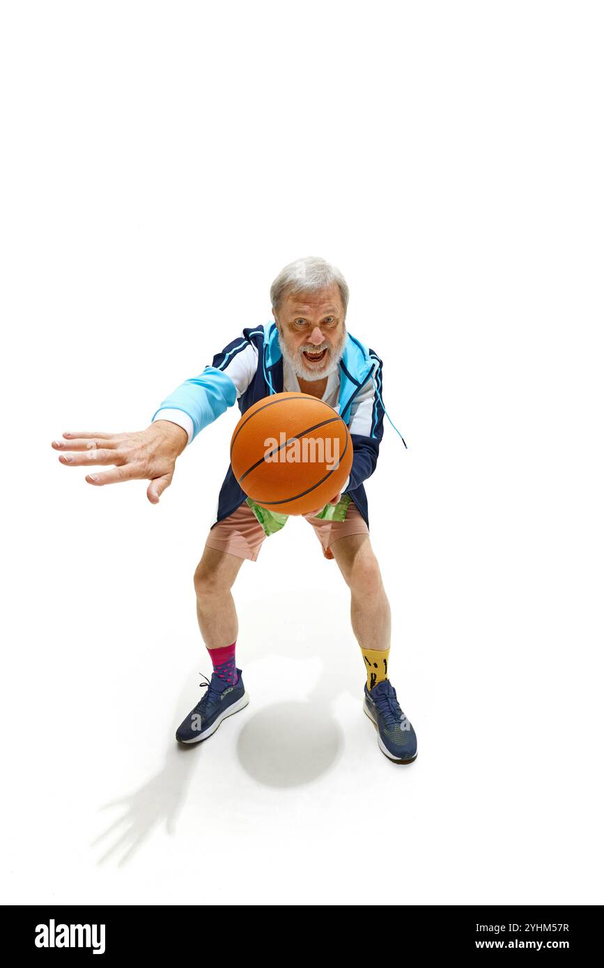 Happy mature man ready to hit ball, levitating in mid-air, and looking ...