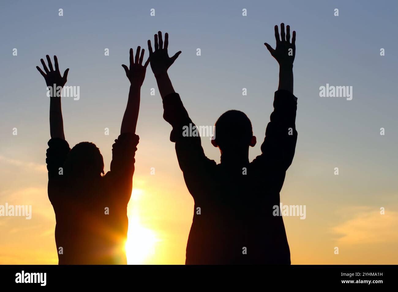 young couple hands up silhouette Stock Photo - Alamy