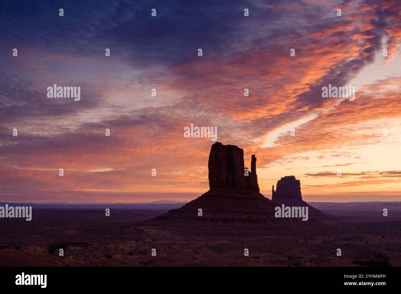 A fiery sunrise sky glowing above the East and West Mittens. Monument ...