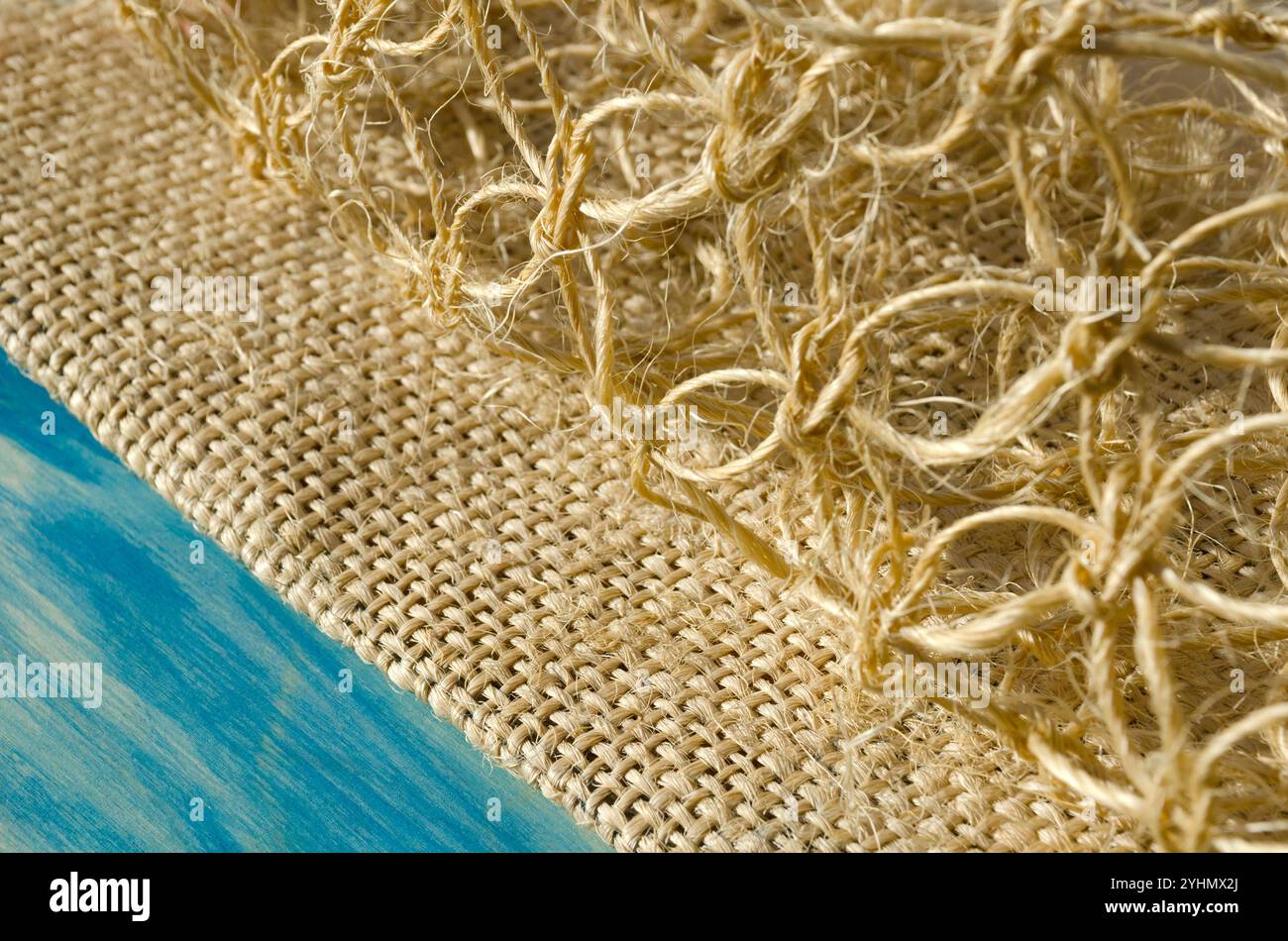 Macrame weaving from straw on a turquoise background. Hobby, needlework ...