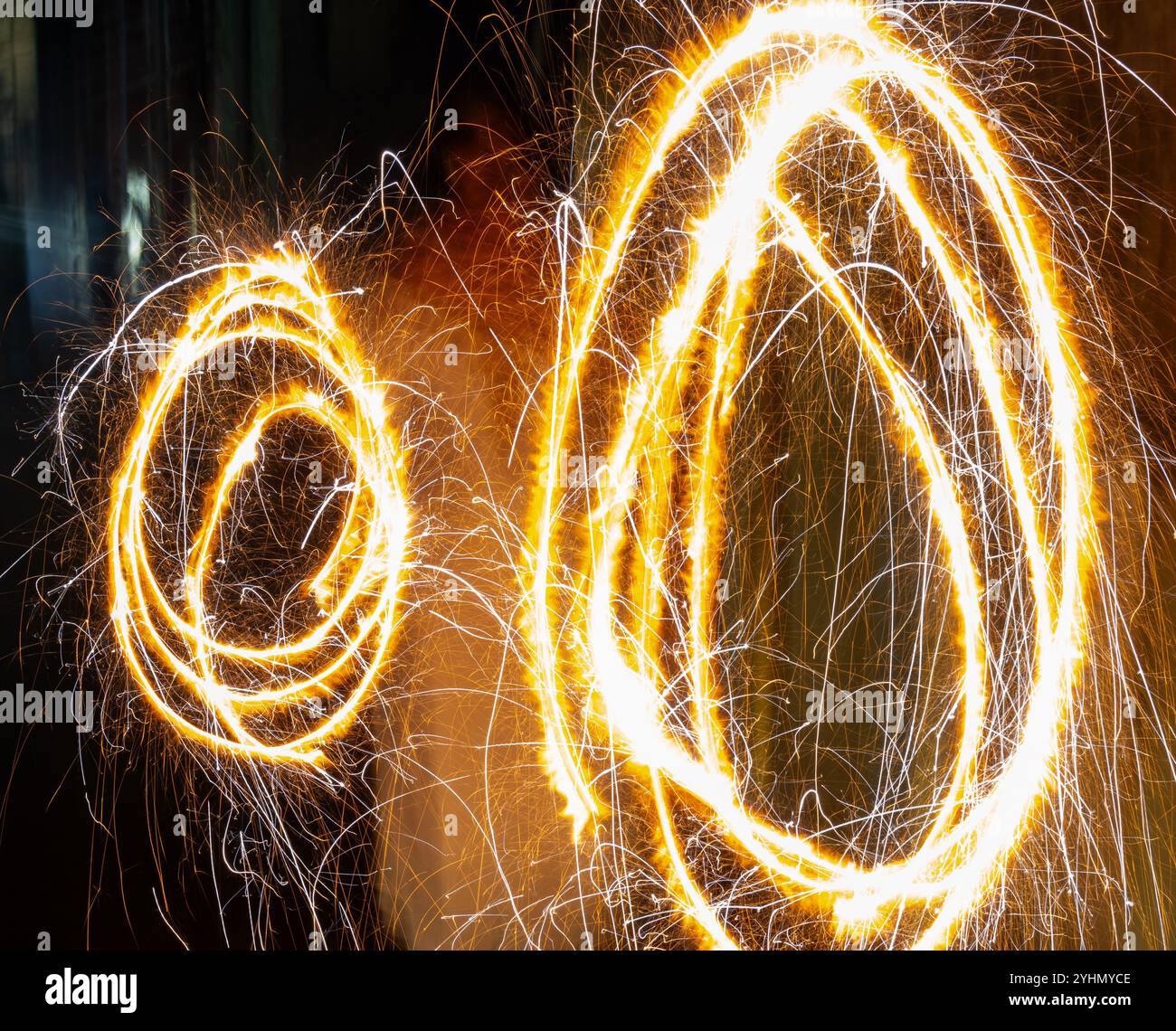 Golden light trails dance in the night, creating mesmerizing circles of ...