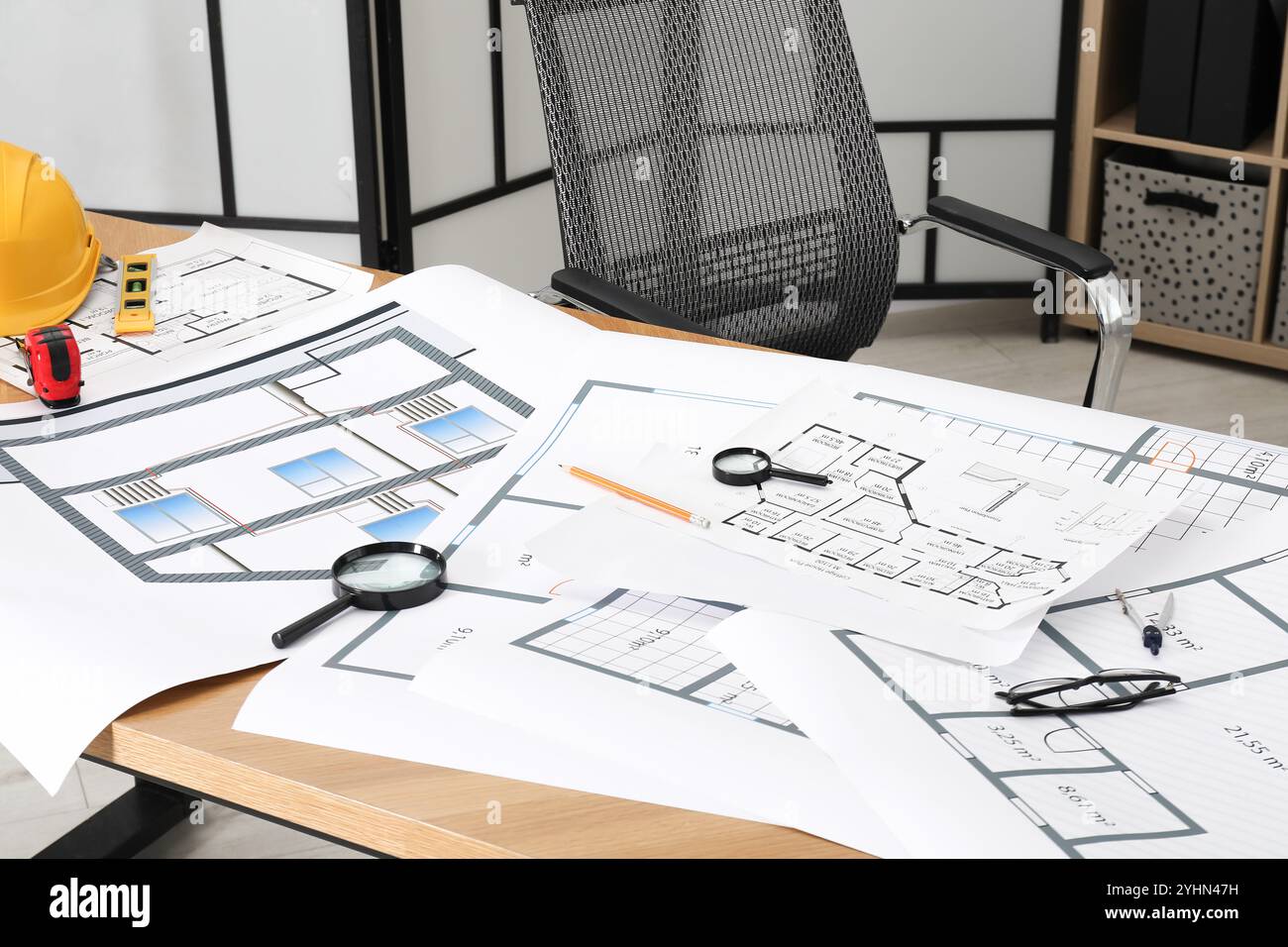 Different engineering drawings and tools on wooden table in architect`s ...