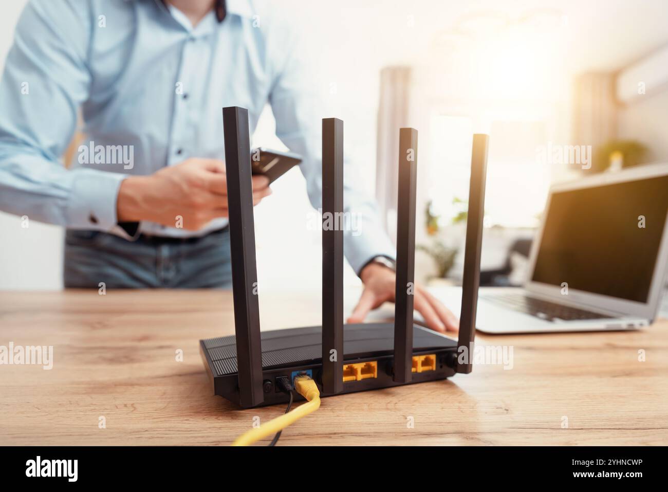 Black wifi router with four antennas. Man using smart phone with fast ...