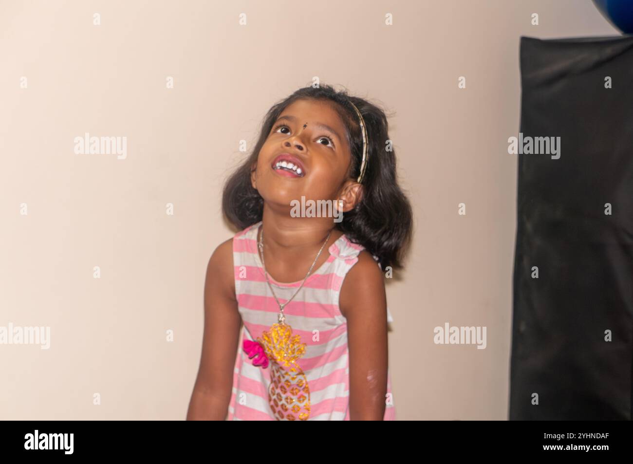Curious little girl gazing upwards with awe and excitement Stock Photo ...