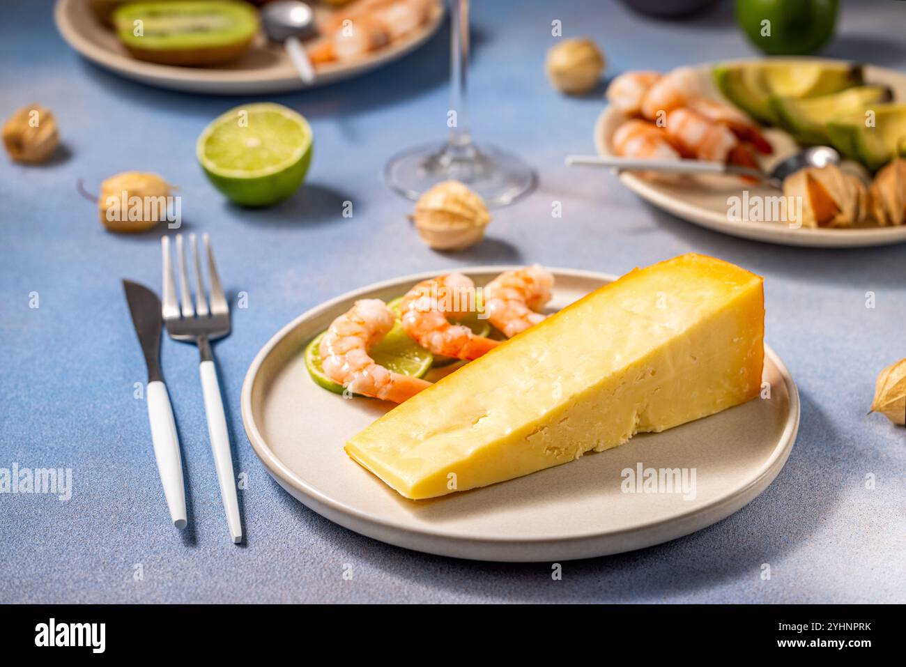 Delicious cheddar cheese served with cooked shrimps and lime wedges ...