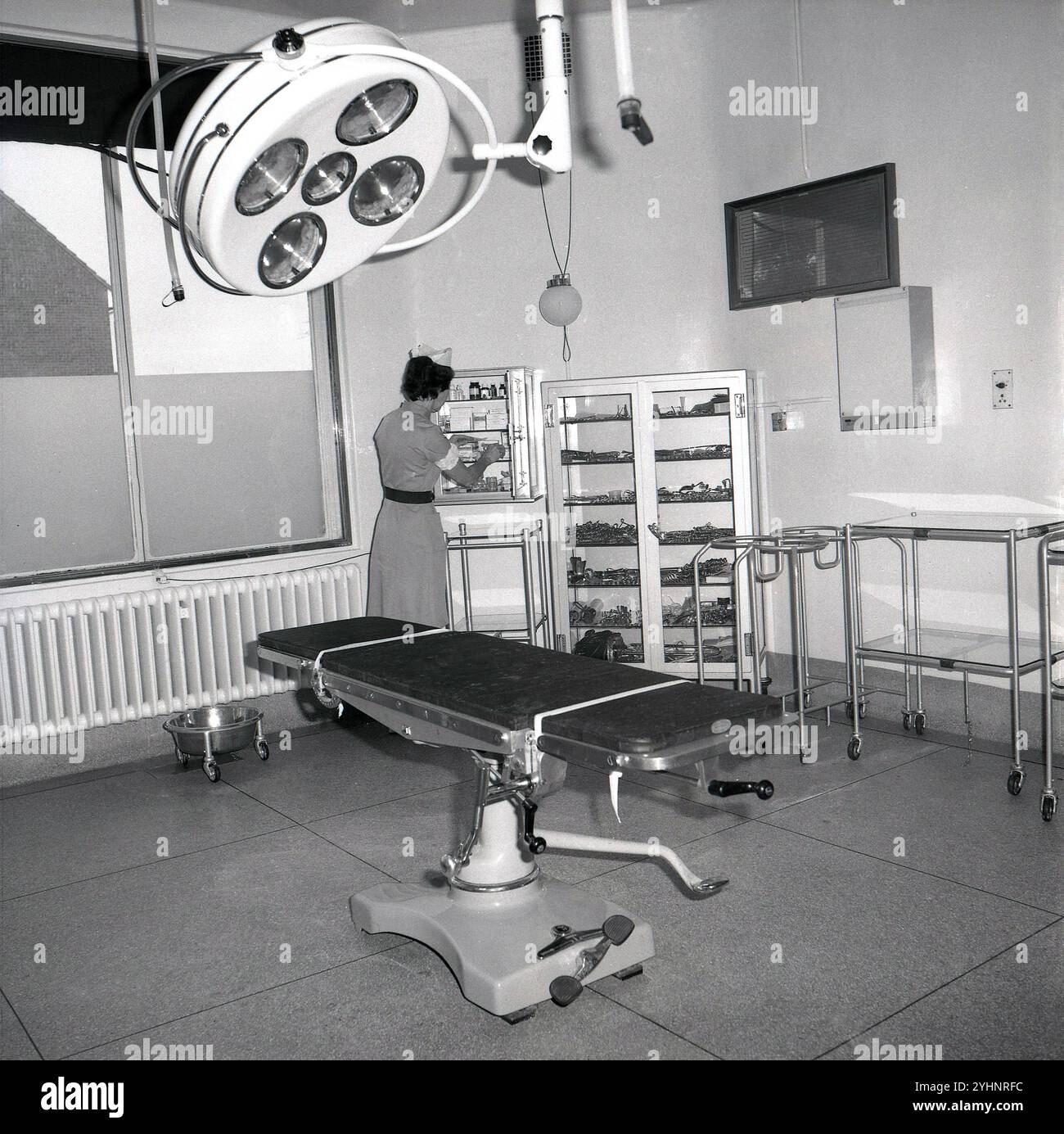 1979, historical, a female nurse at an open medical cabinet inside a ...