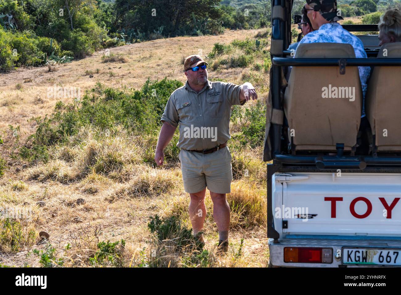 A ranger guide showing and talking to a group of tourists in a safari ...