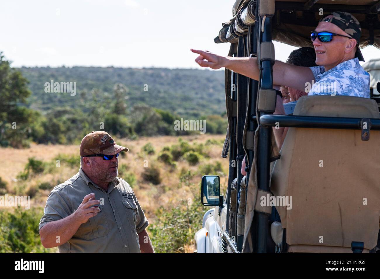 A ranger guide showing and talking to a group of tourists in a safari ...