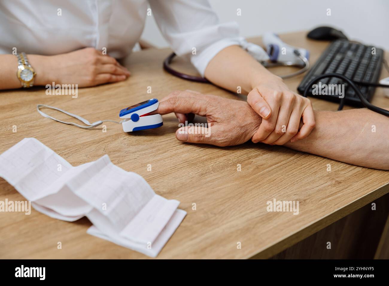 Healthcare professional using pulse oximeter on patients finger during ...