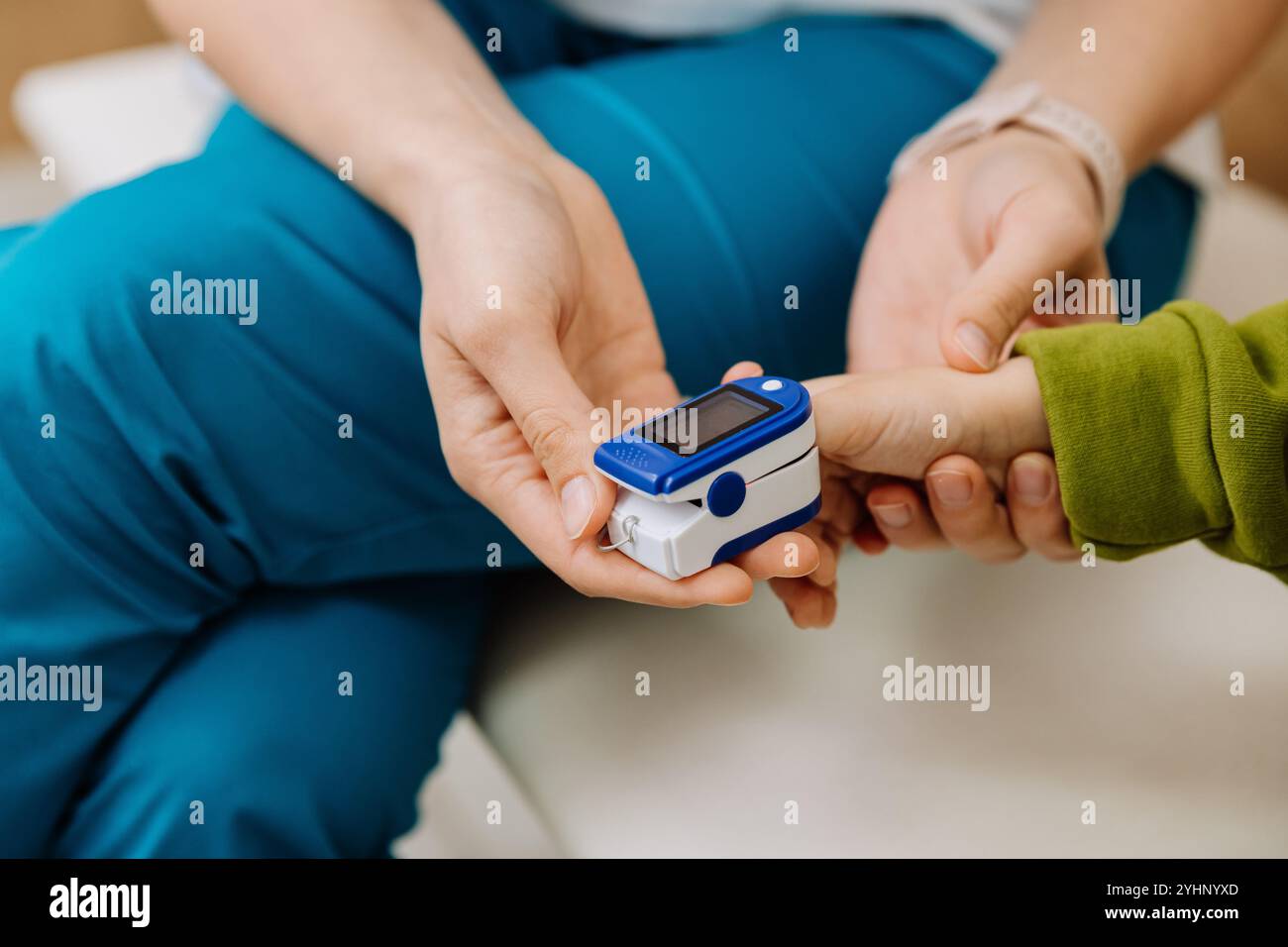 Nurse checks childs oxygen level with a pulse oximeter in a healthcare ...
