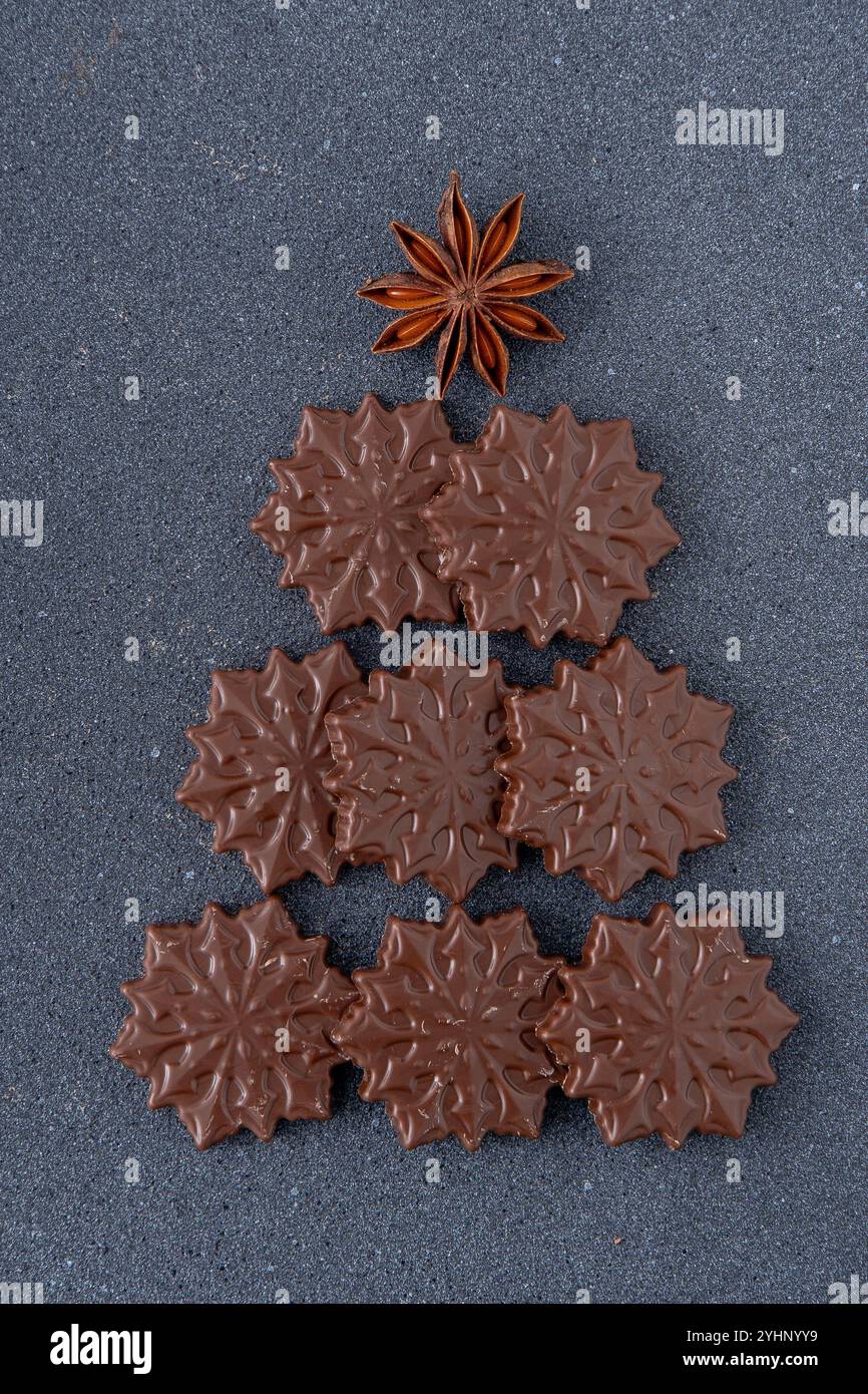 Chocolate candies in the shape of snowflakes. Brown food background ...