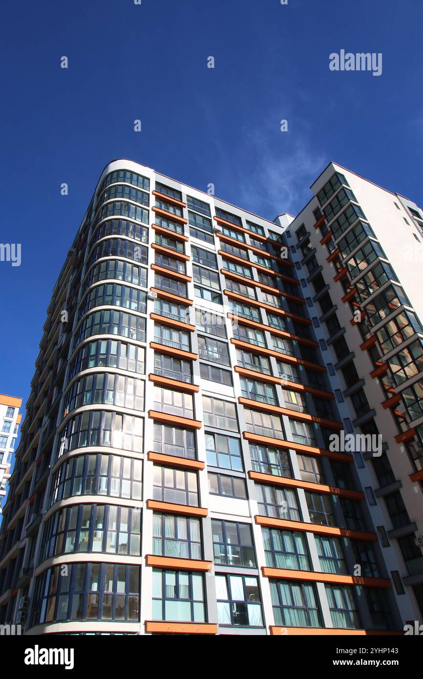 A very tall building reaching high into the sky with a vibrant blue sky ...