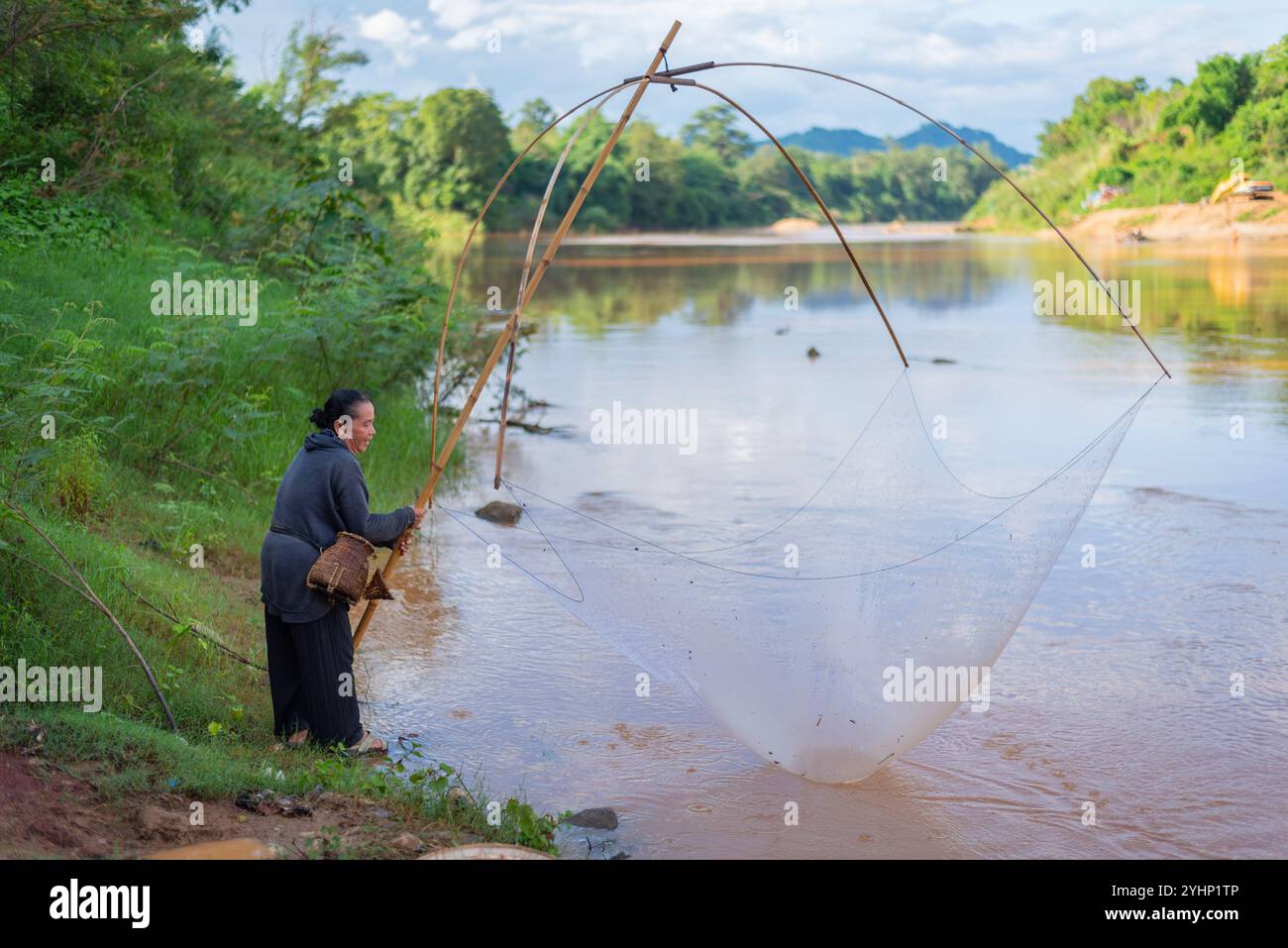 Xepon, Laos - June 17, 2023: a local lady fishes with a cross net at ...