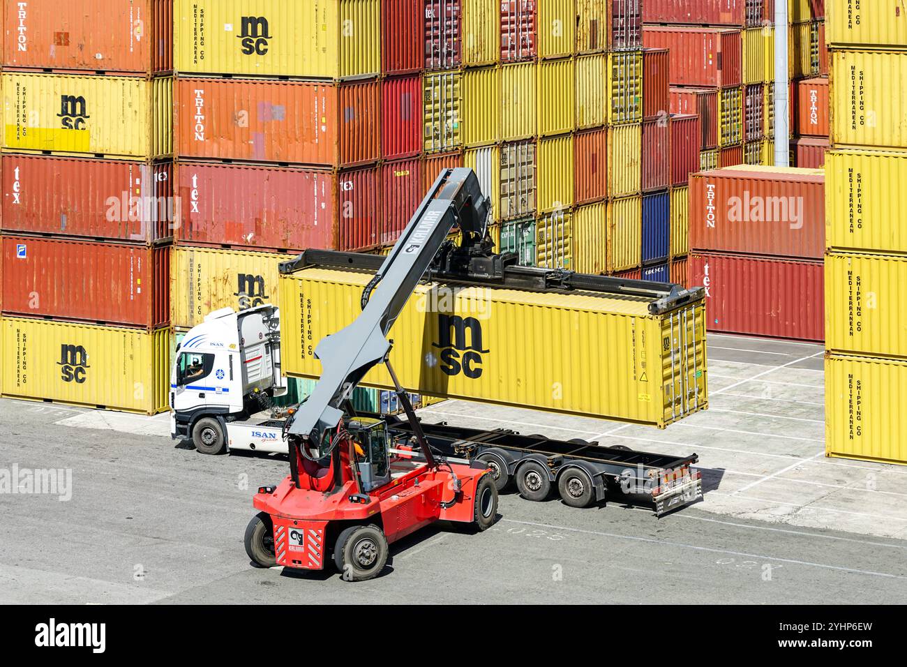 The forklift loads the cargo container onto the truck platform, stacked ...