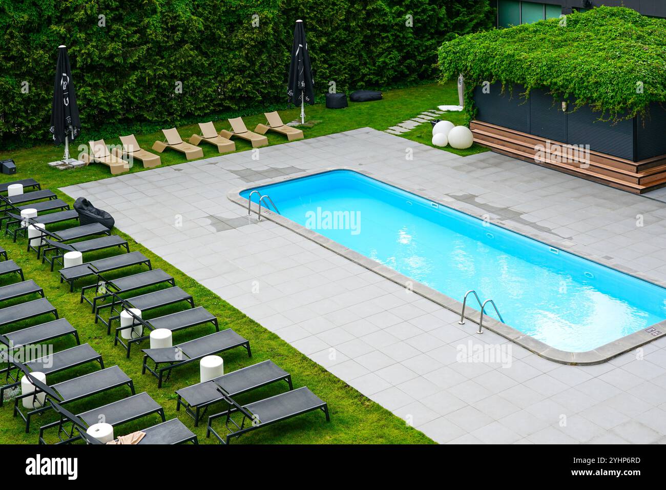 Luxury vacation resort hotel garden with swimming pool and sun loungers ...