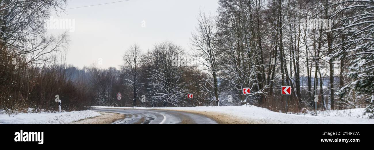 A panoramic view of a winter road curving sharply, surrounded by icy ...